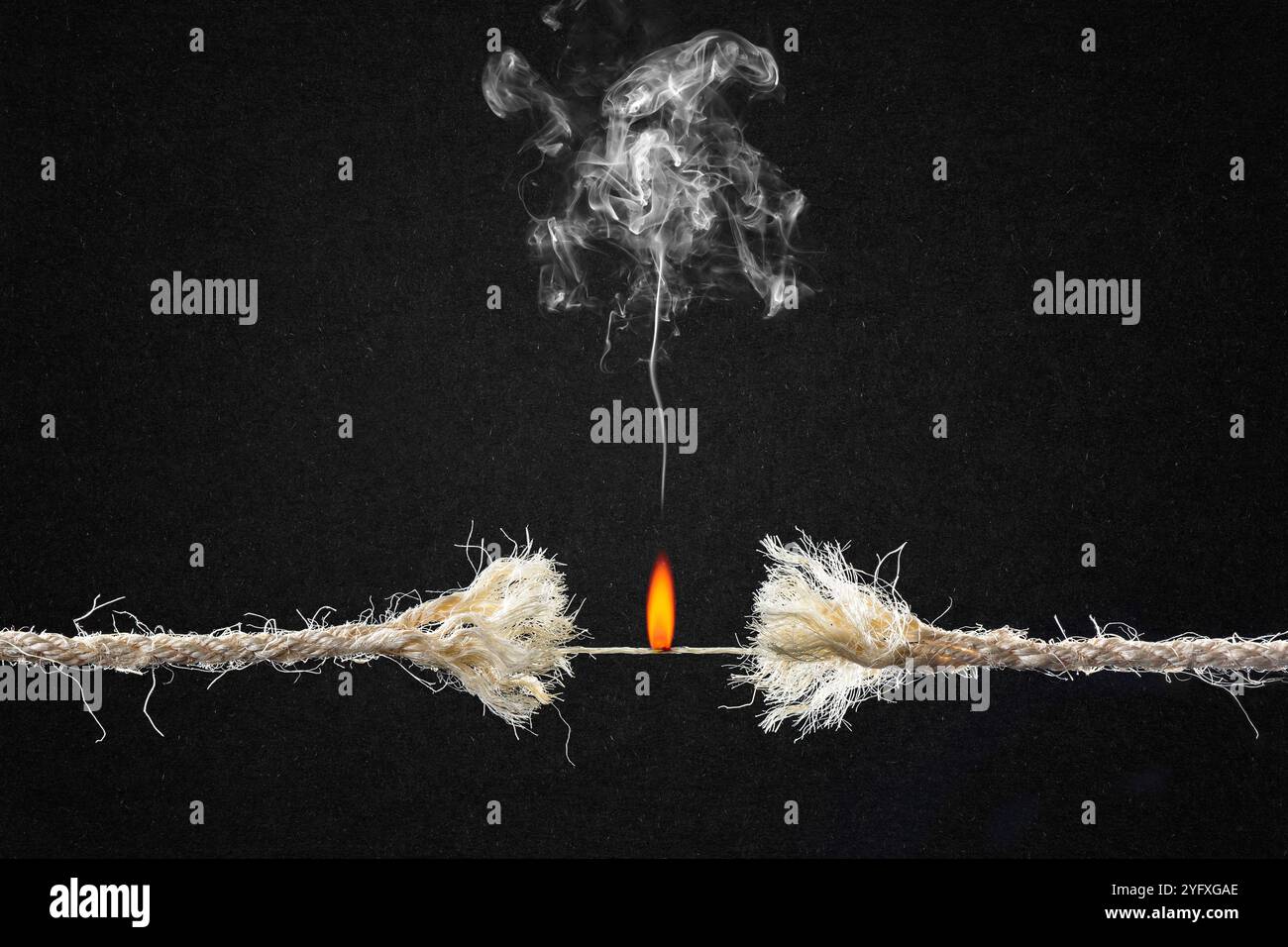 Burning Frayed Rope About to Break Against Textured Black Paper ...