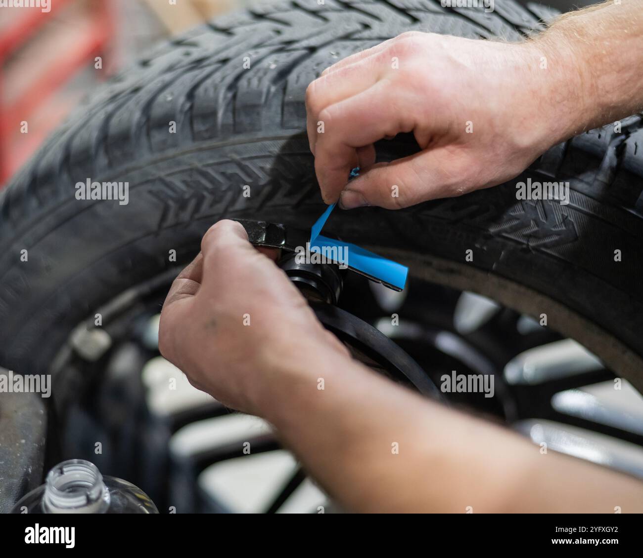 A mechanic attaches balancing weights to a wheel Stock Photo - Alamy