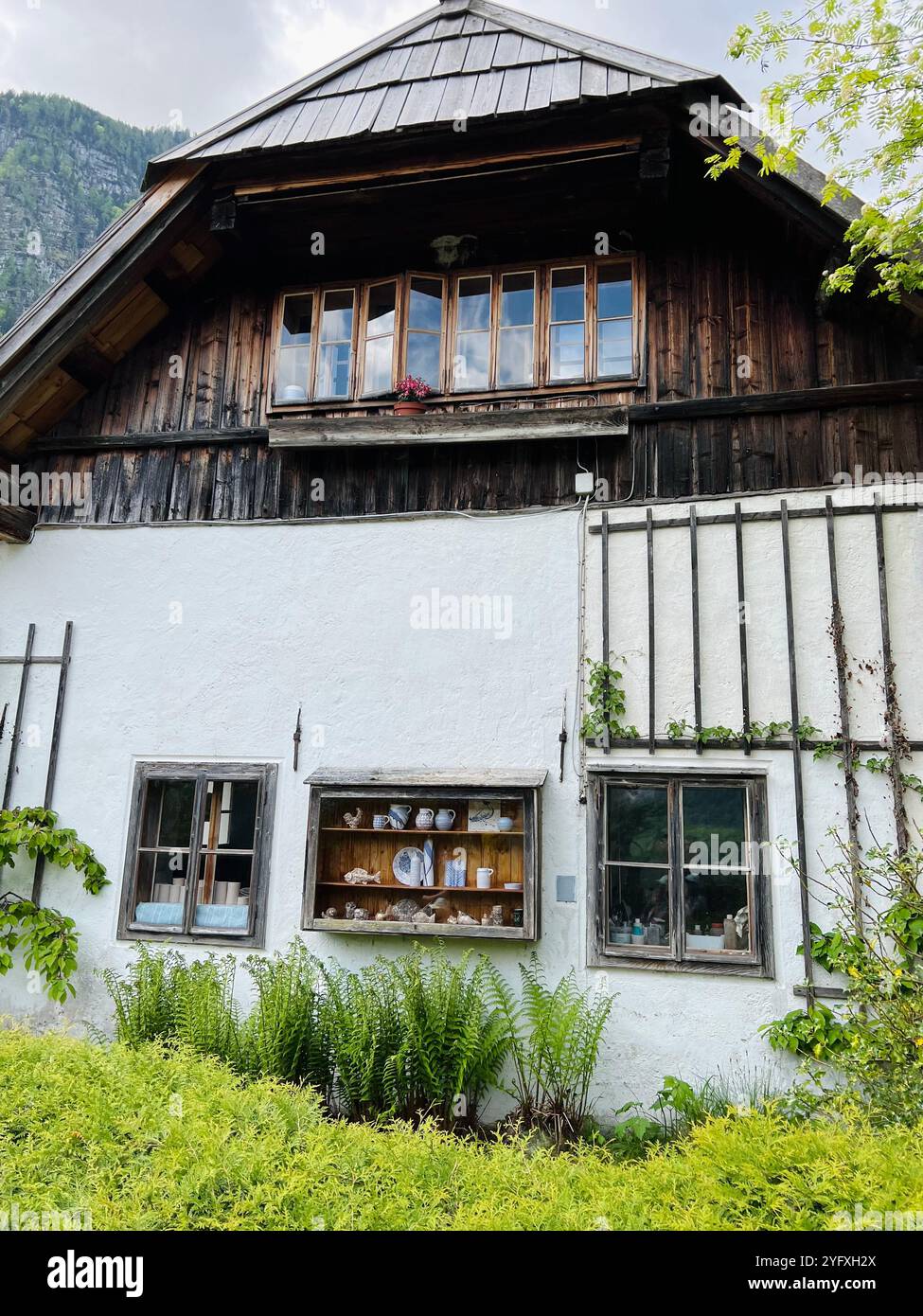 A beautiful rustic house with dark wooden accents, surrounded by green ...