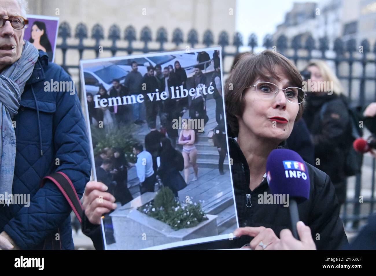 Paris, France. 05th Nov, 2024. A woman holds a placard with a drawing ...
