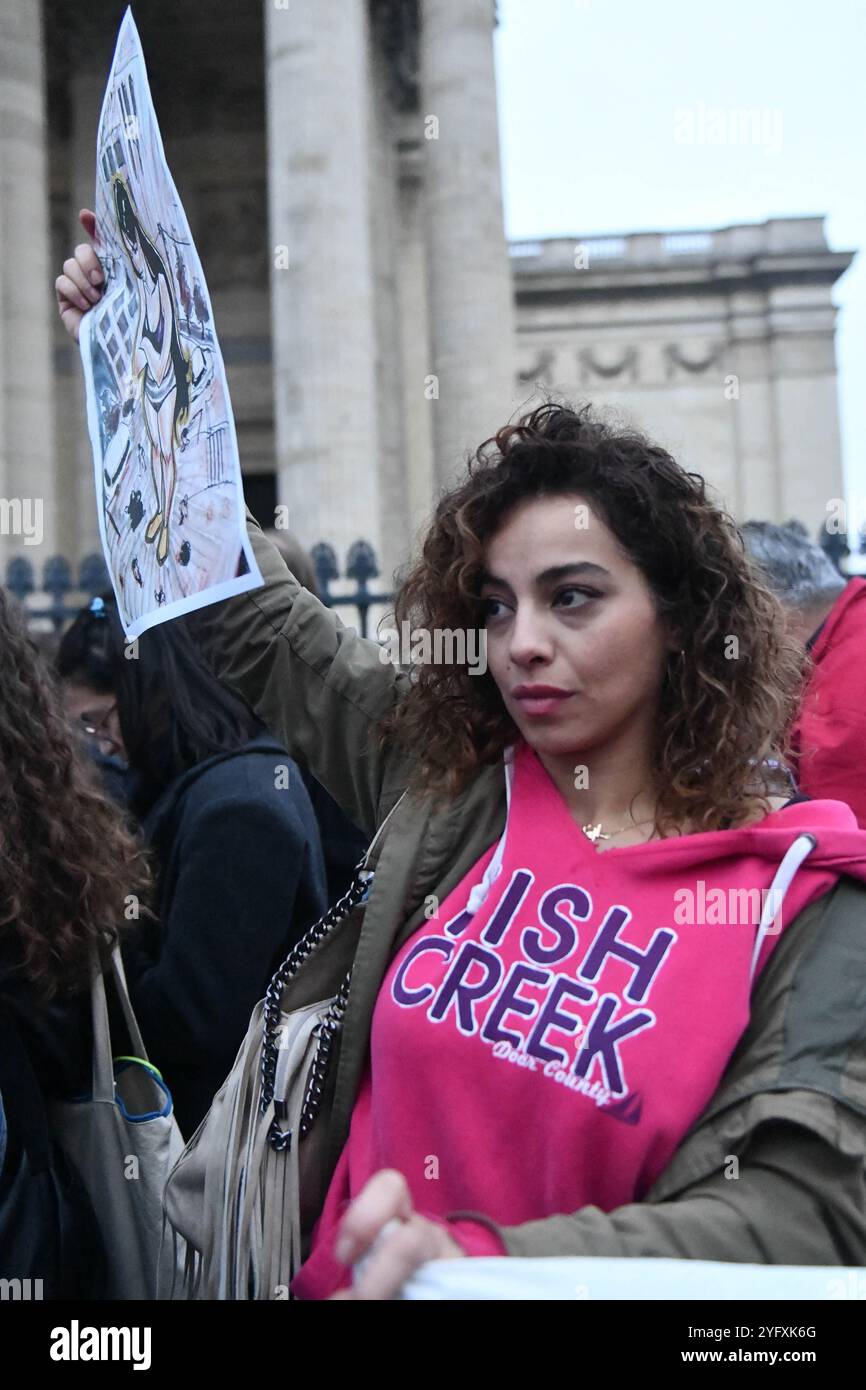 Paris, France. 05th Nov, 2024. A woman holds a placard with a drawing ...