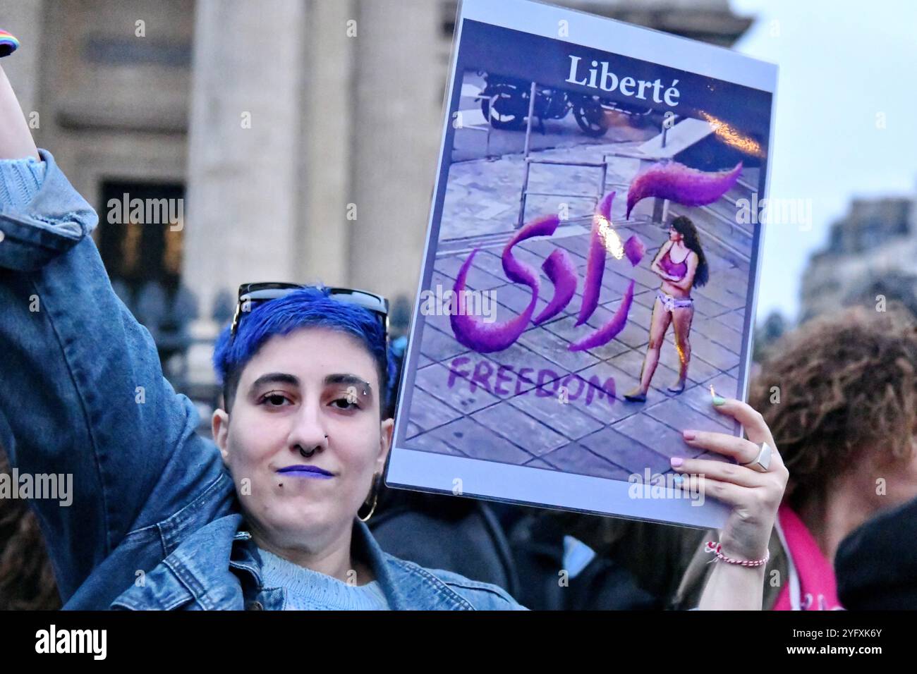 Paris, France. 05th Nov, 2024. A woman holds a placard with a drawing ...