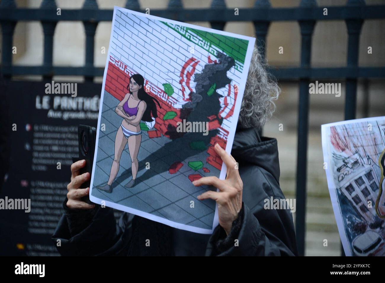 Paris, France. 05th Nov, 2024. A woman holds a placard with a drawing ...