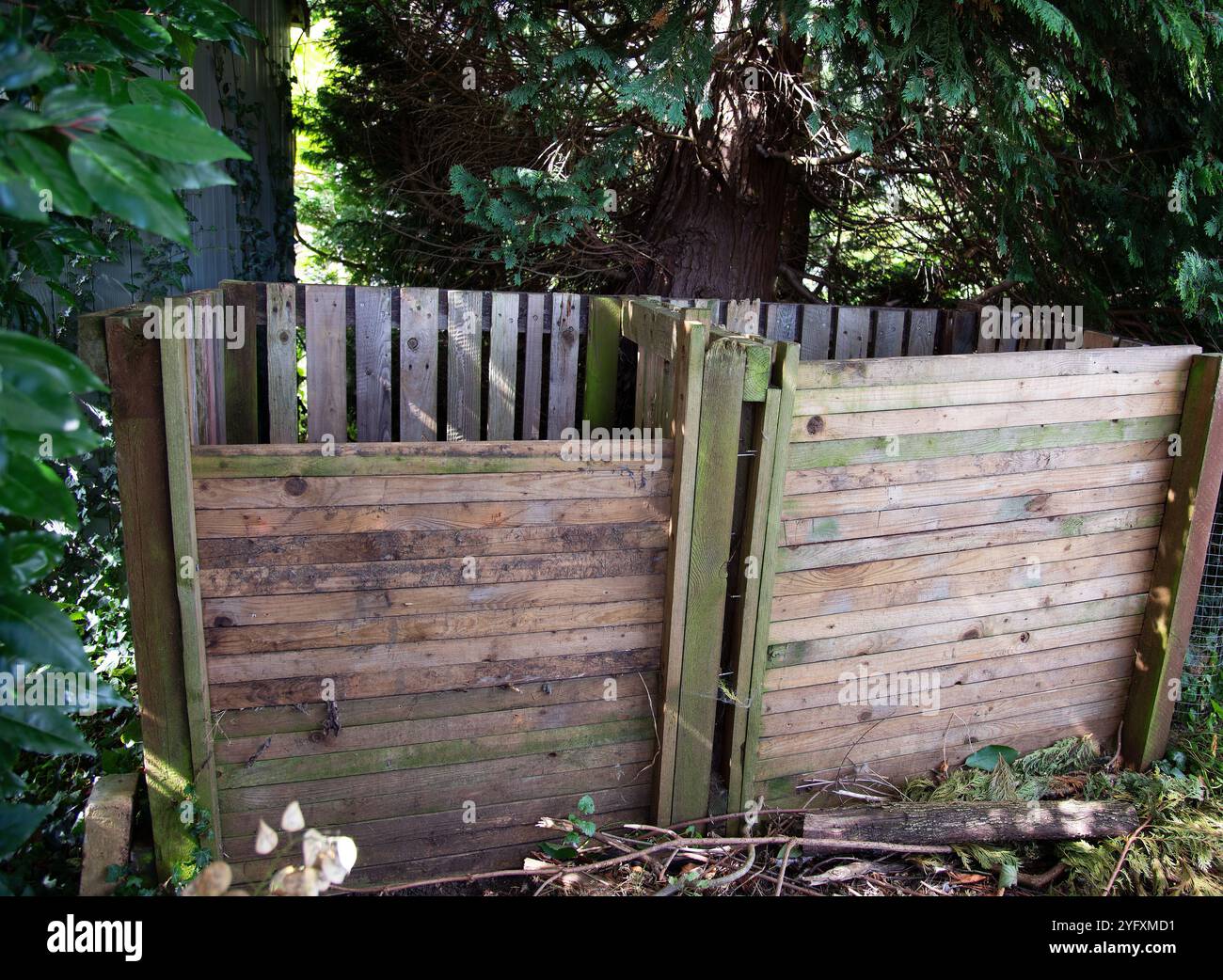 Garden compost bins in a country garden are tucked behind the old ...