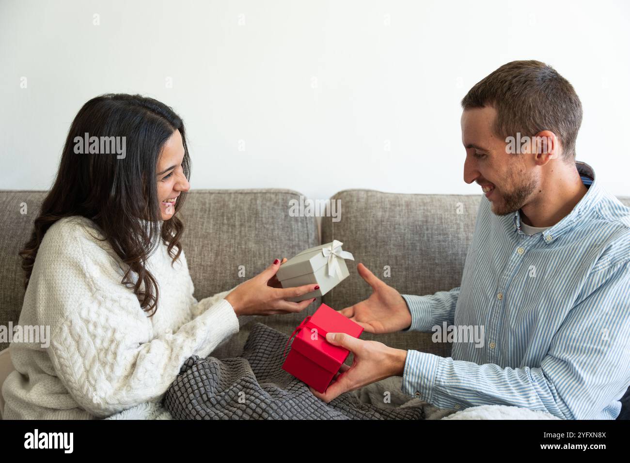 Exchanging Christmas Gifts Between Husband And Wife Stock Photo - Alamy