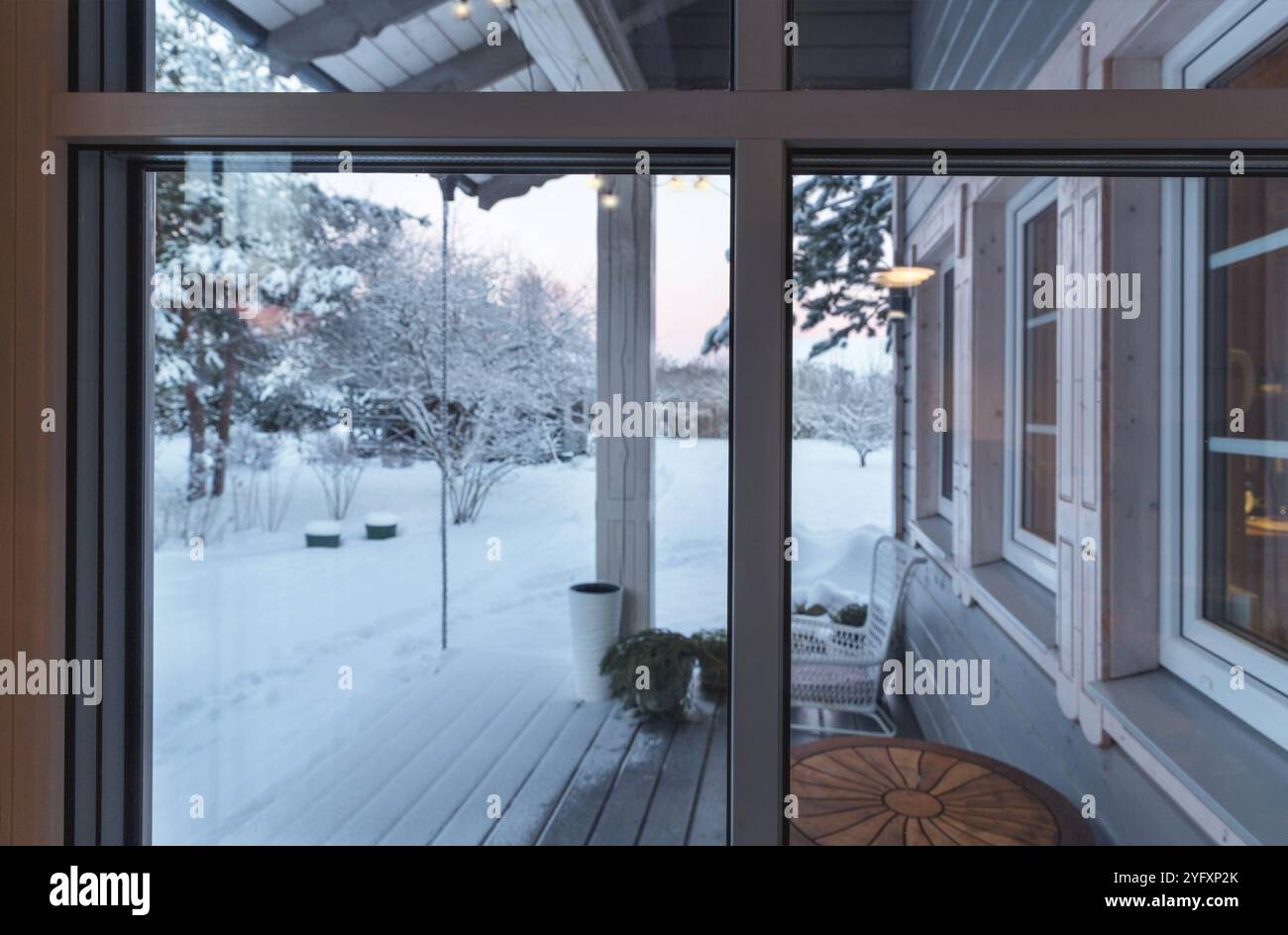 Home vinyl windows with winter view of cozy terrace, snow-covered trees ...