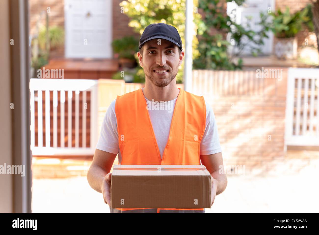 Smiling adult delivery man carrying hi-res stock photography and images ...