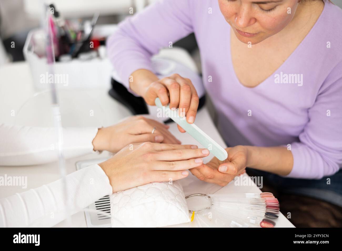 Woman performing manicure shaping hi-res stock photography and images ...
