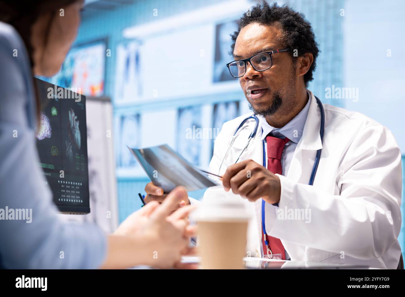 Male physician doing an x ray diagnostics scan interpretation during ...