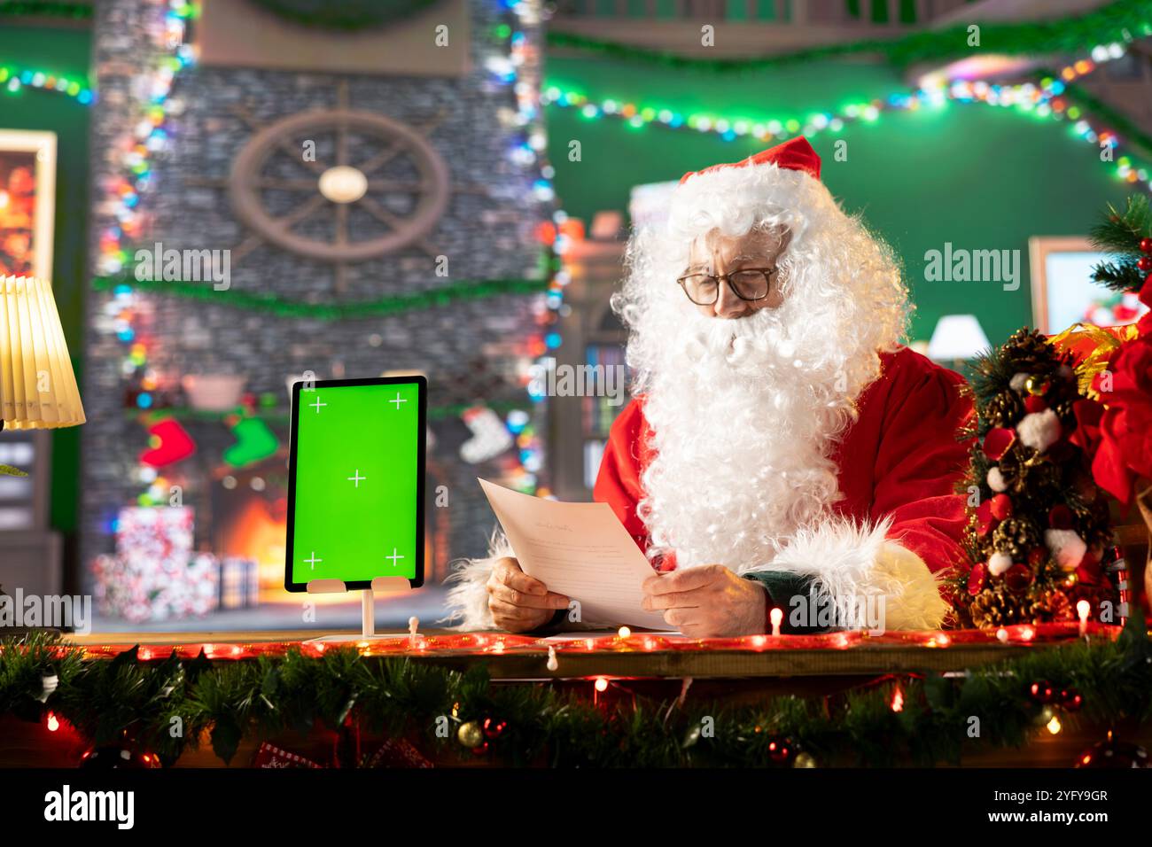 Father Christmas reads letters with wishes next to green screen on ...