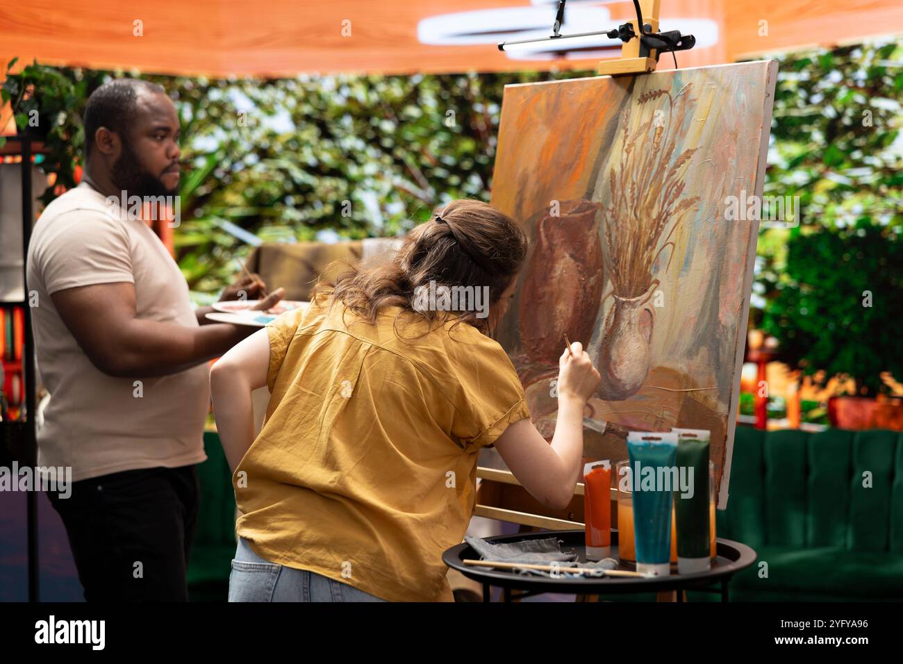 Team of artists painting a beautiful rustic creation on canvas, mixing ...