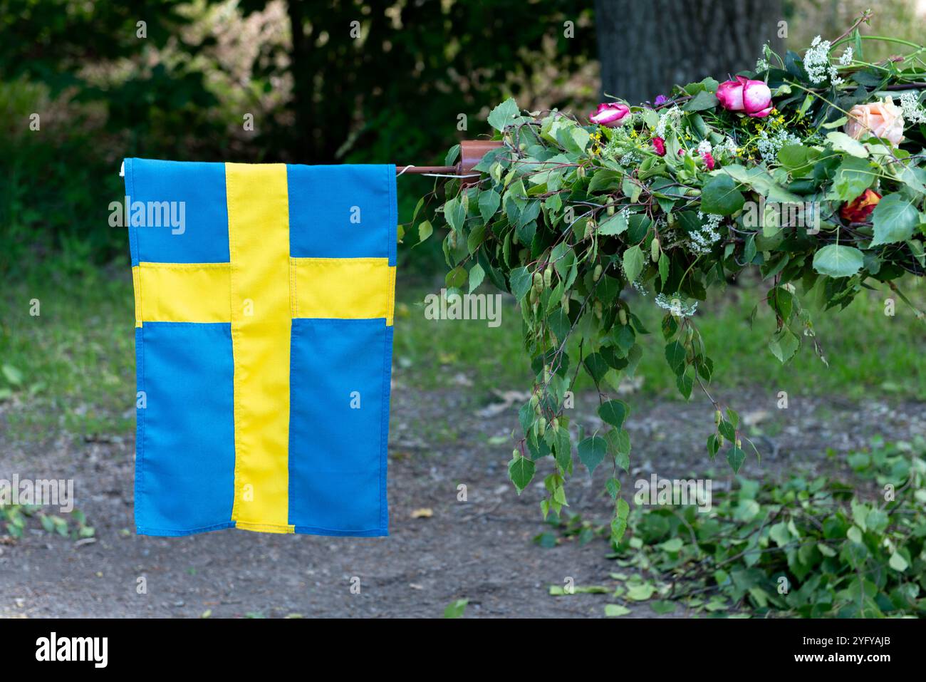 Traditional midsummer pole with small Swedish flag Stock Photo - Alamy
