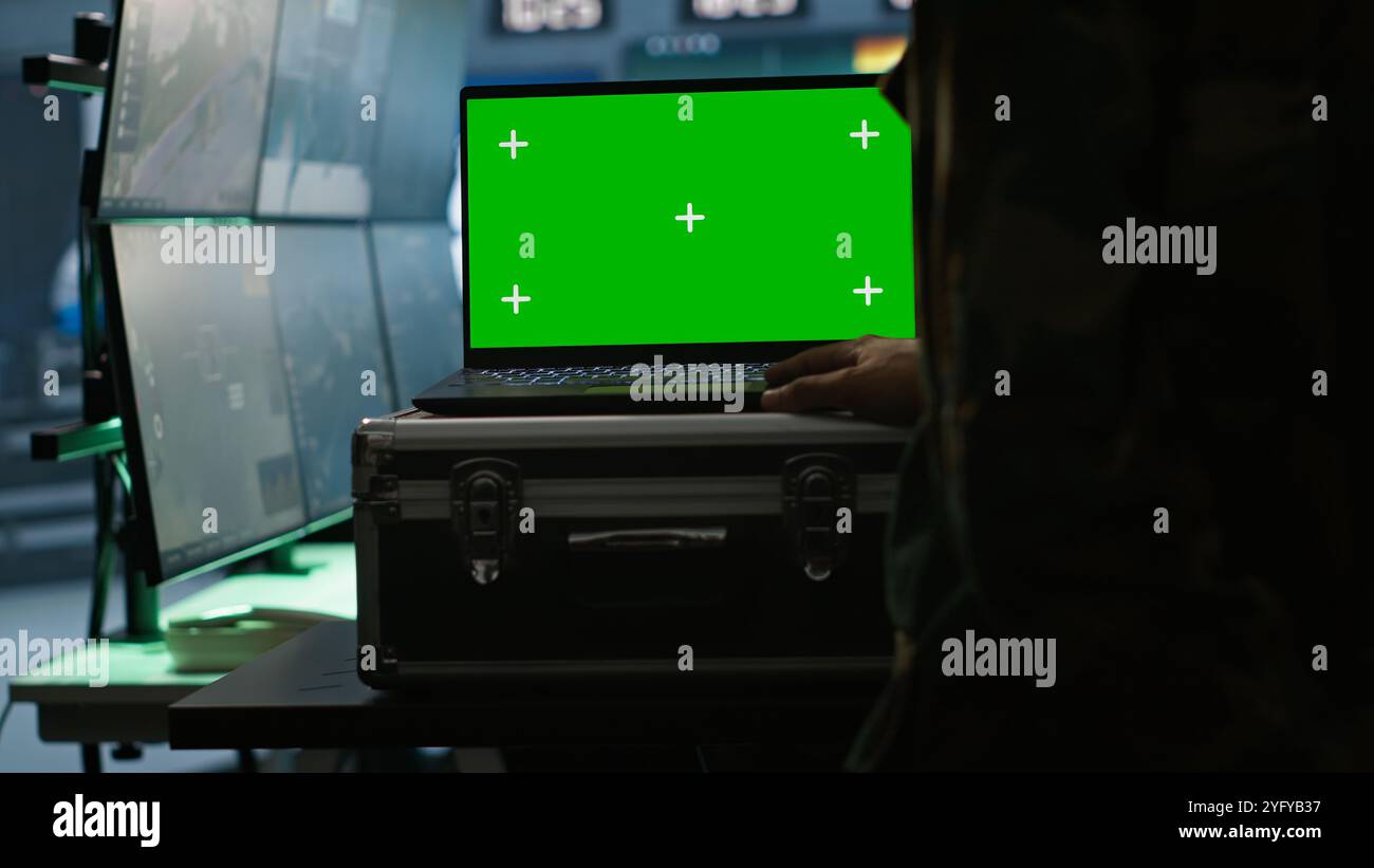 Army specialist working in war room operating surveillance tech, evaluating target data on ...