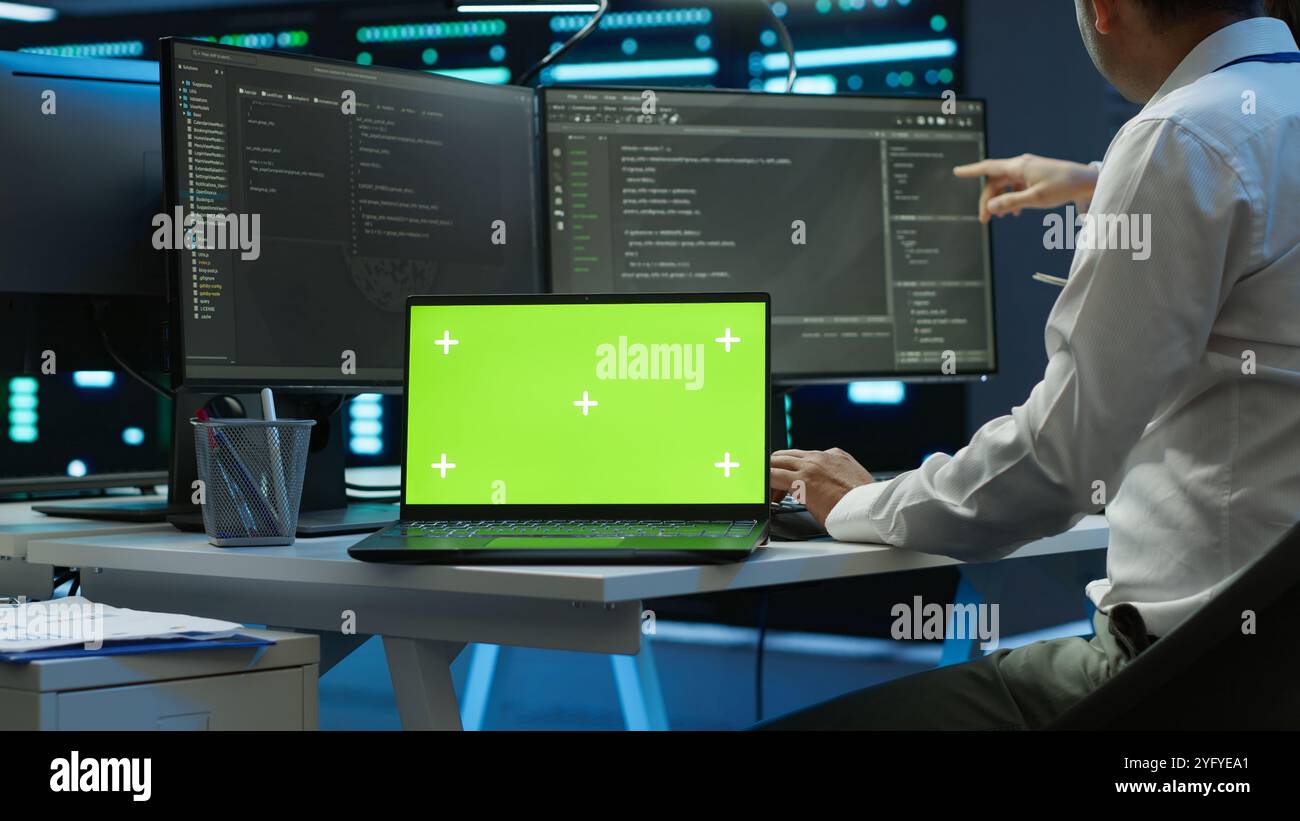 Zoom in on green screen laptop used by data center worker troubleshooting issues. Engineer uses ...