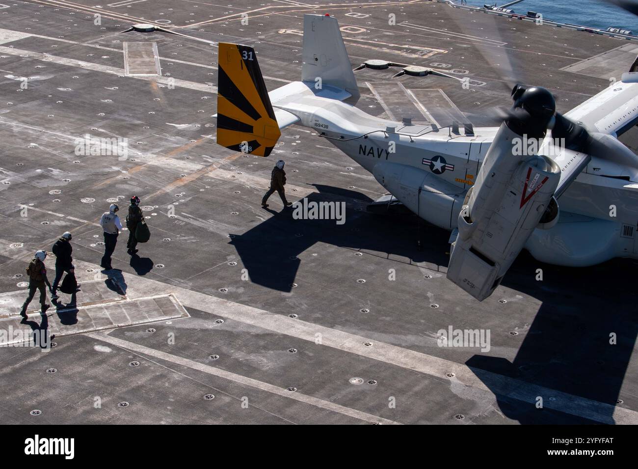 Sailors prepare to board a CMV-22 Osprey tiltrotor aircraft, assigned ...