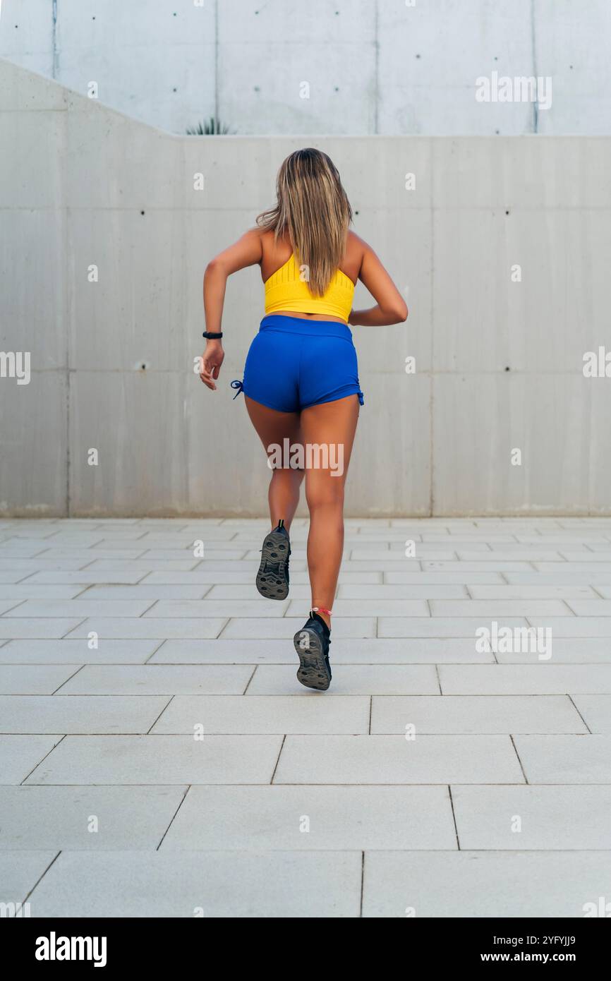 Young fit woman running away from camera outdoors Stock Photo - Alamy