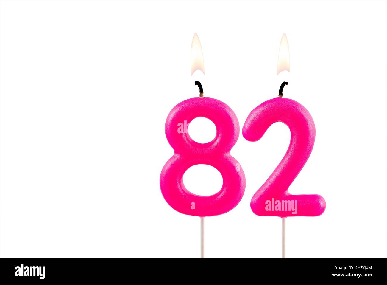 Pink number 82 birthday candle lit on white background Stock Photo - Alamy