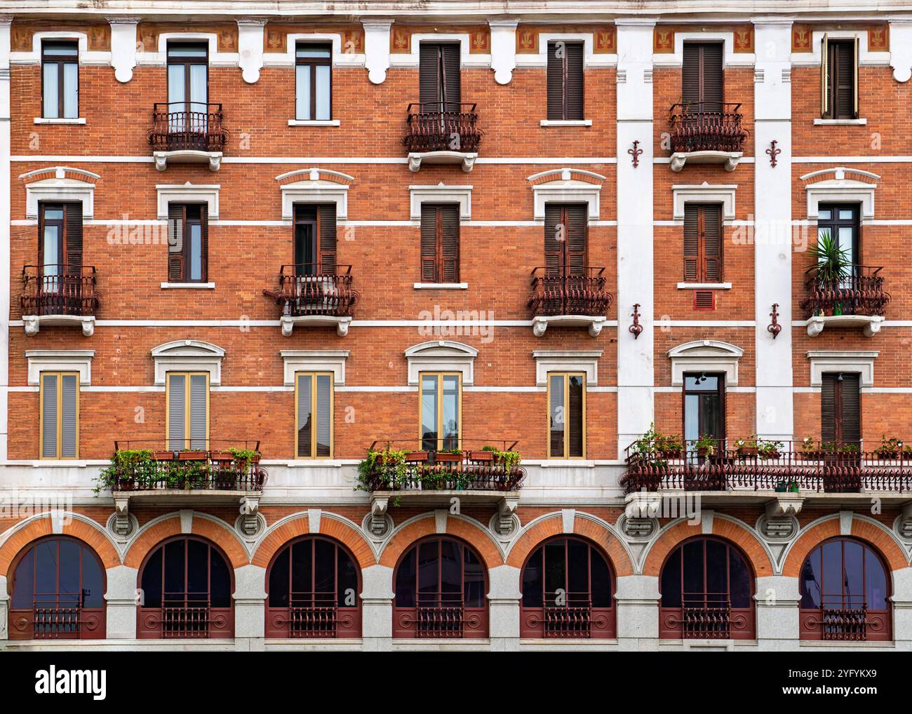 Close-up of a European apartment building with red brick facade, arched ...
