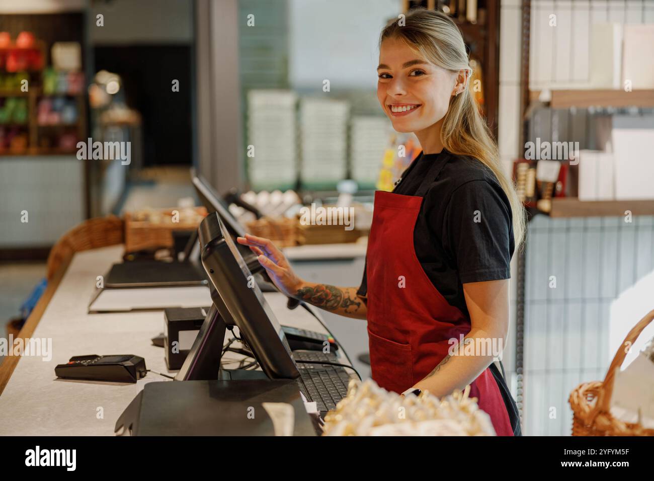 A Smiling Barista at the Cafe Counter, Engaging with Customers Using a ...