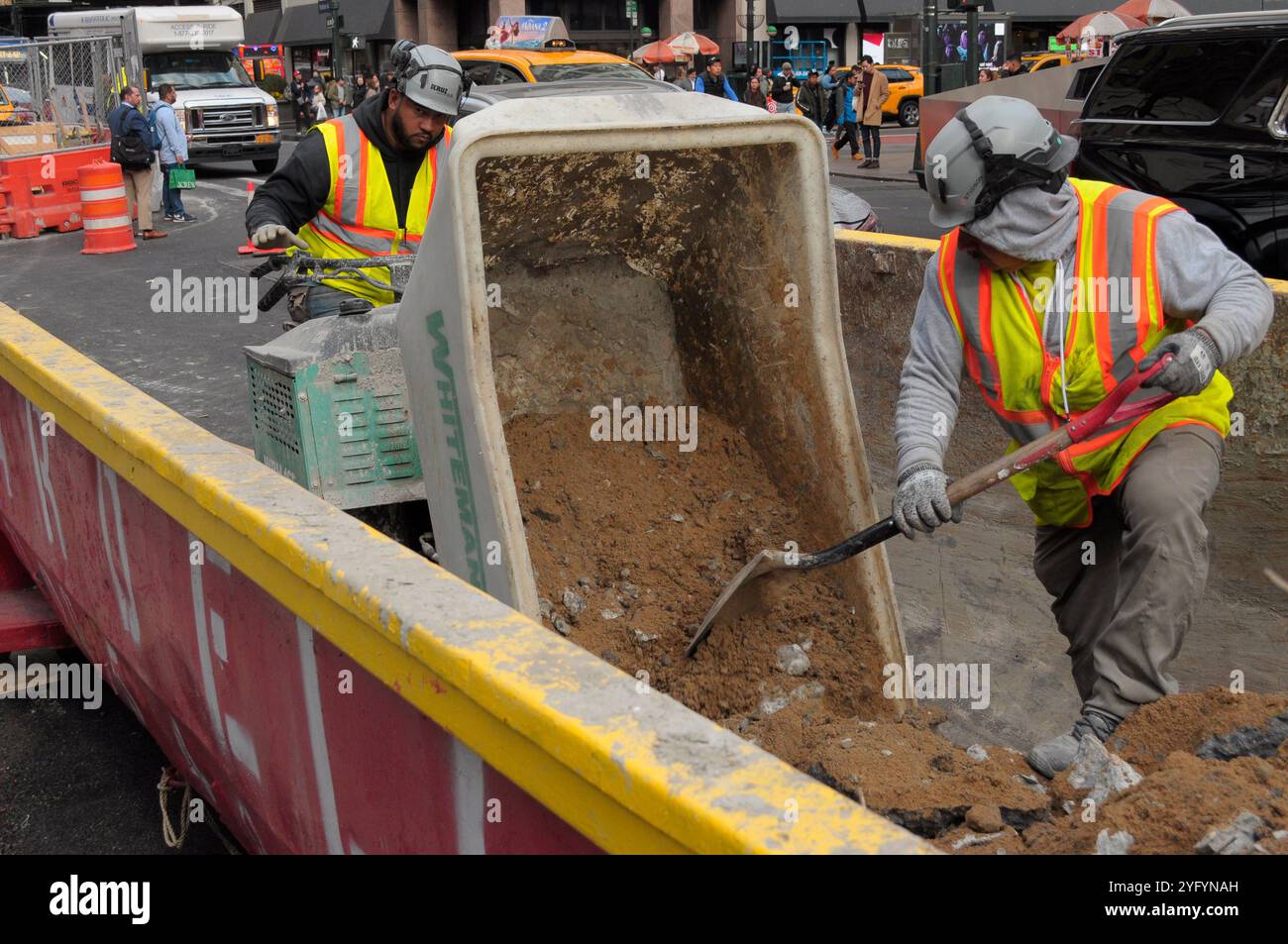 Workers pour dirt inside of a metal bin in Manhattan, New York City ...