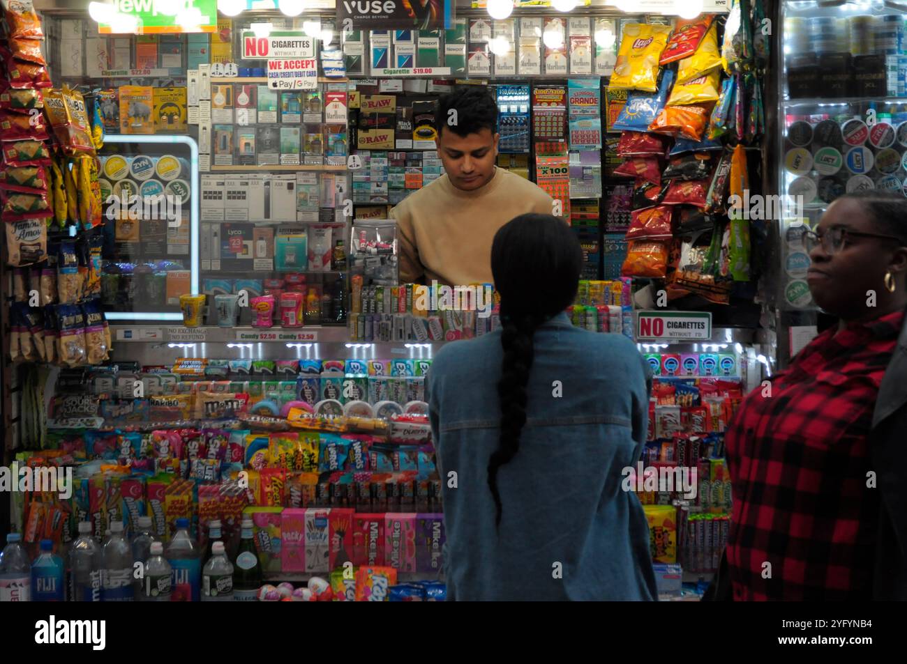 A vendor works inside of a shop on the street in Manhattan, New York ...