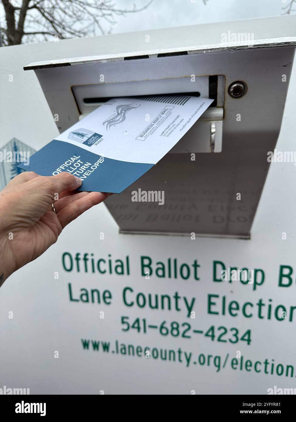 A hand dropping a ballot in a ballot box in Eugene, Oregon for the 2024 ...