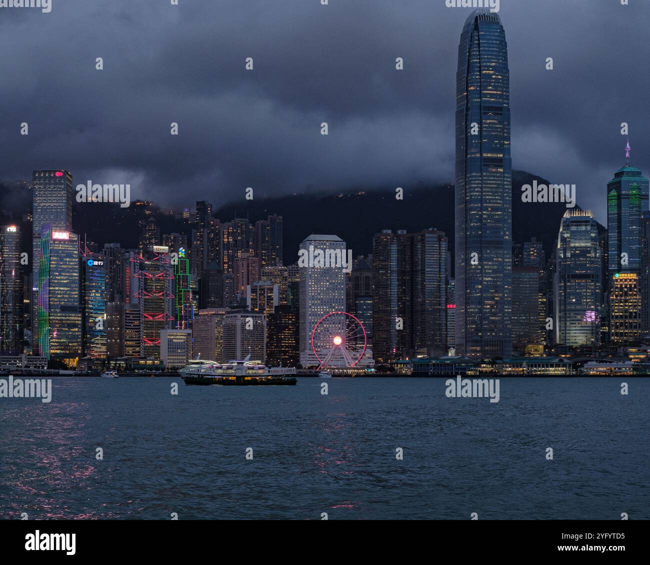 Discover the stunning night skyline of Hong Kong, where vibrant lights reflect on Victoria ...