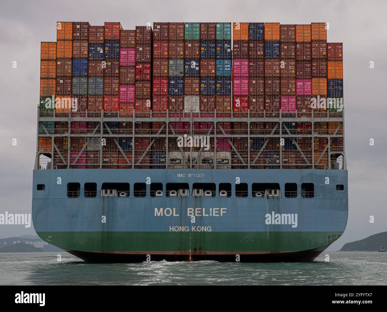 A massive cargo ship loaded with variously colored shipping containers ...