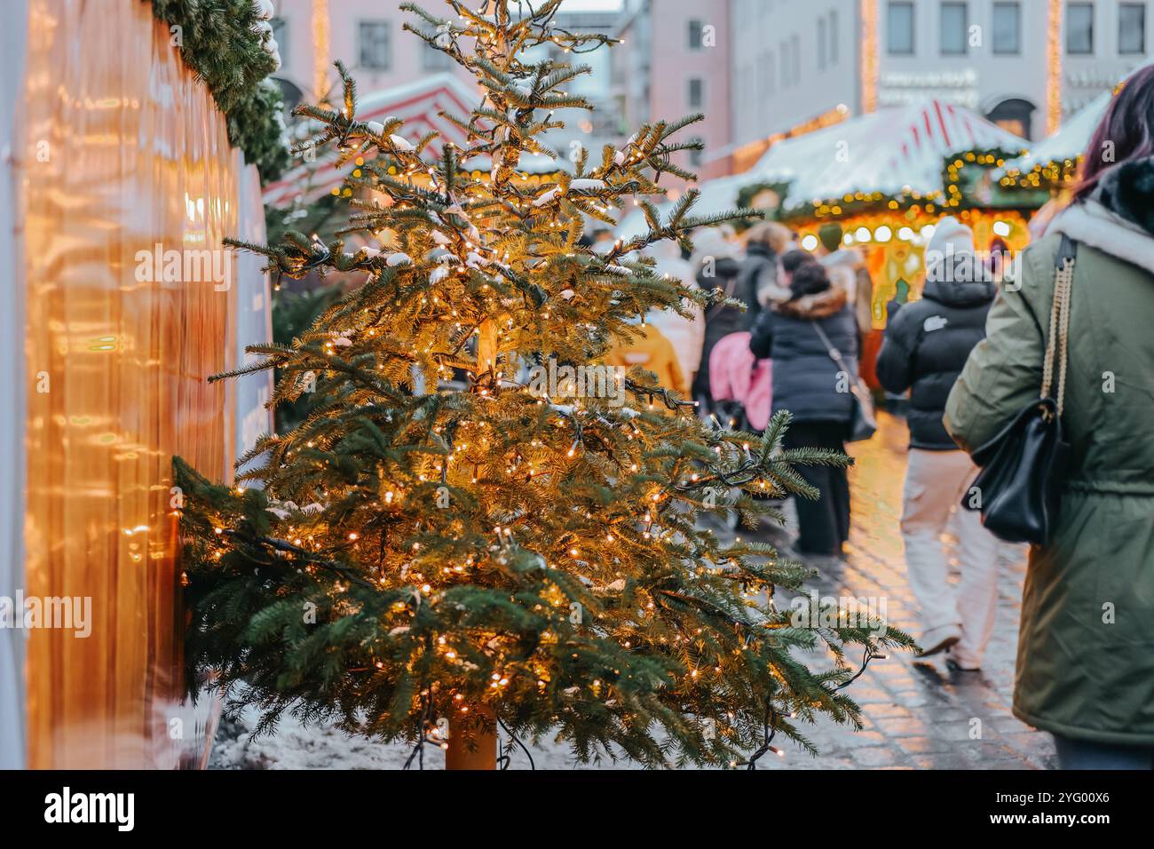 Christmas market.Fir branches with garlands, fair stalls with goods and ...