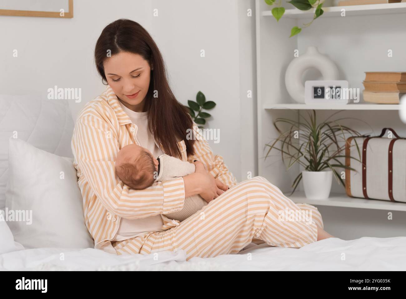 Happy mother holding cute little sleeping baby on bed at home Stock Photo - Alamy