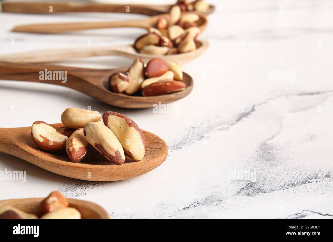 Wooden spoons with tasty Brazil nuts on white background Stock Photo ...