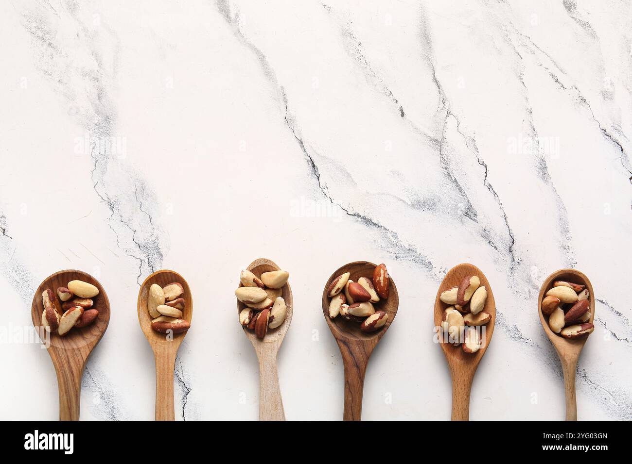 Wooden spoons with tasty Brazil nuts on white background Stock Photo ...