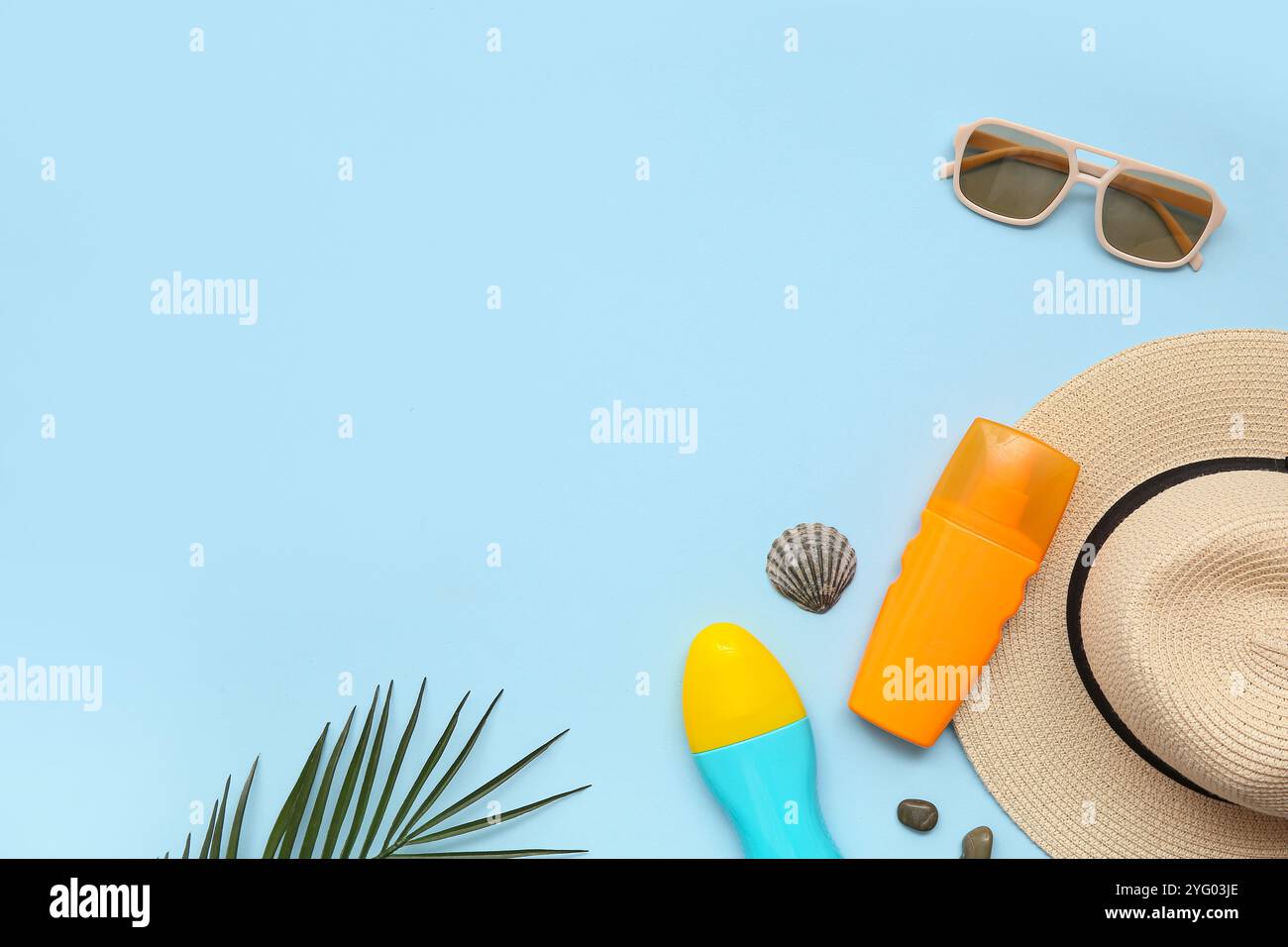 Composition with bottles of sunscreen cream, sunglasses, palm leaf and ...