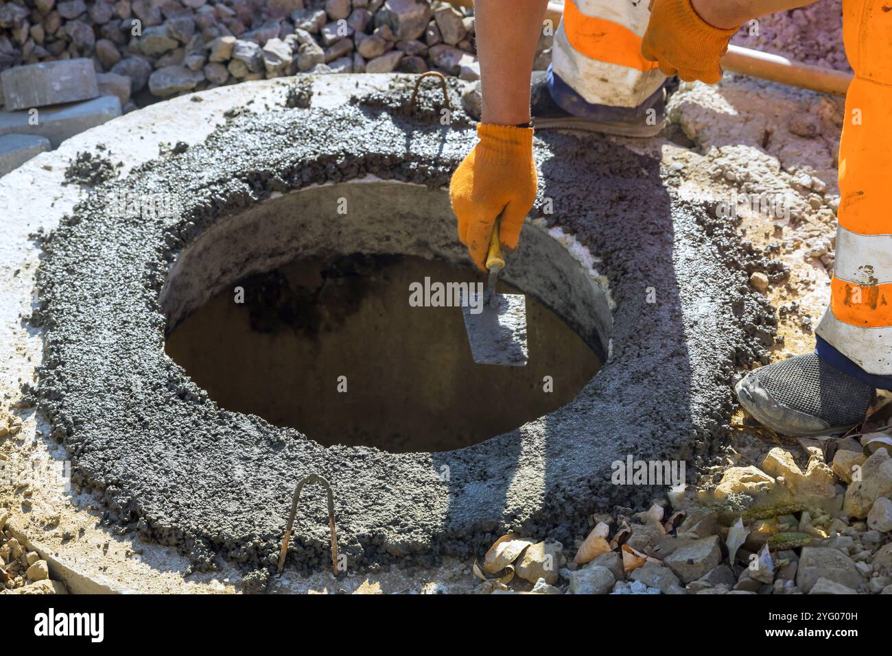 Fresh concrete is applied to fasten blocks forming upper boundary of ...