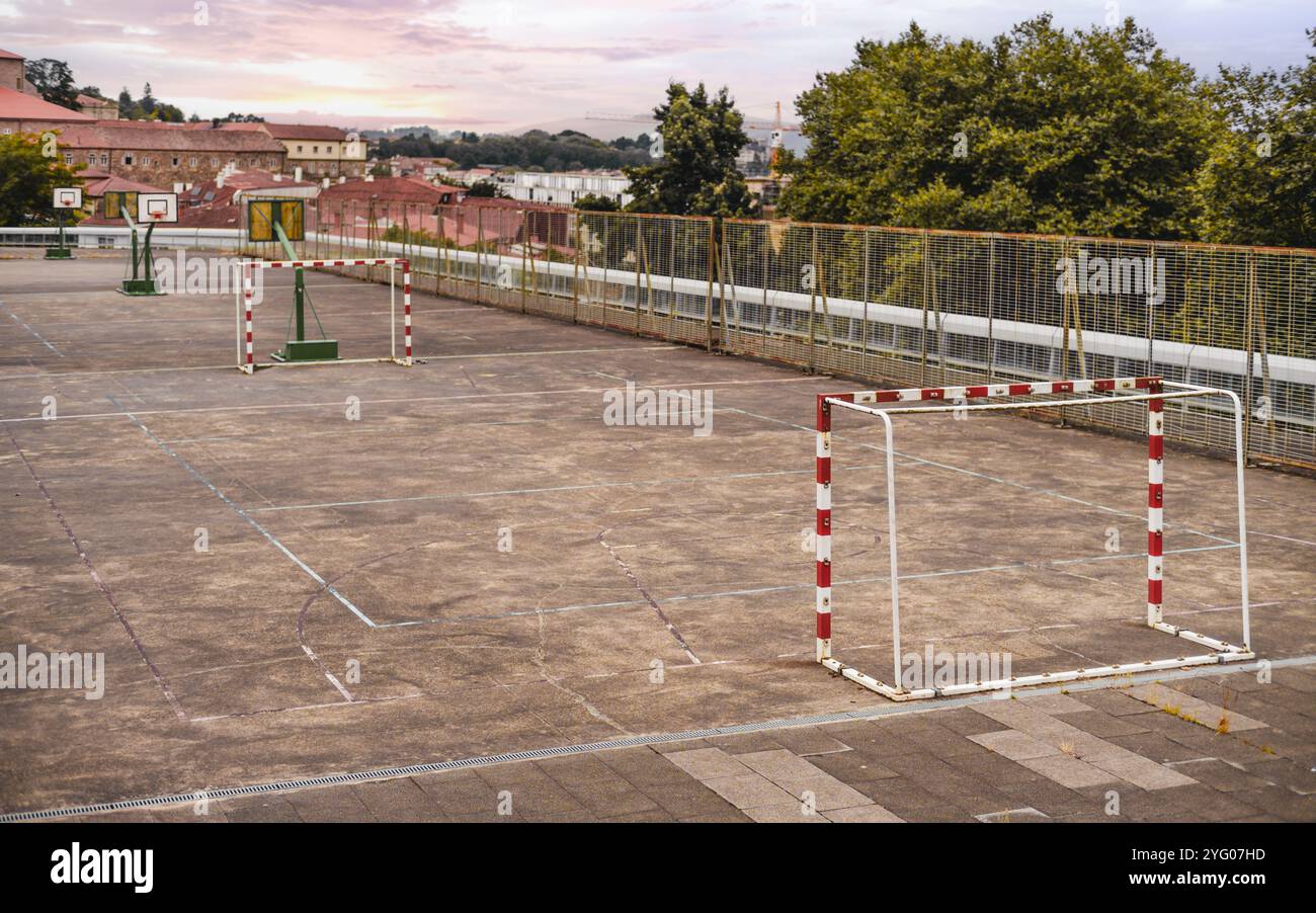 Outdoor rooftop sports court featuring worn, marked concrete ground ...