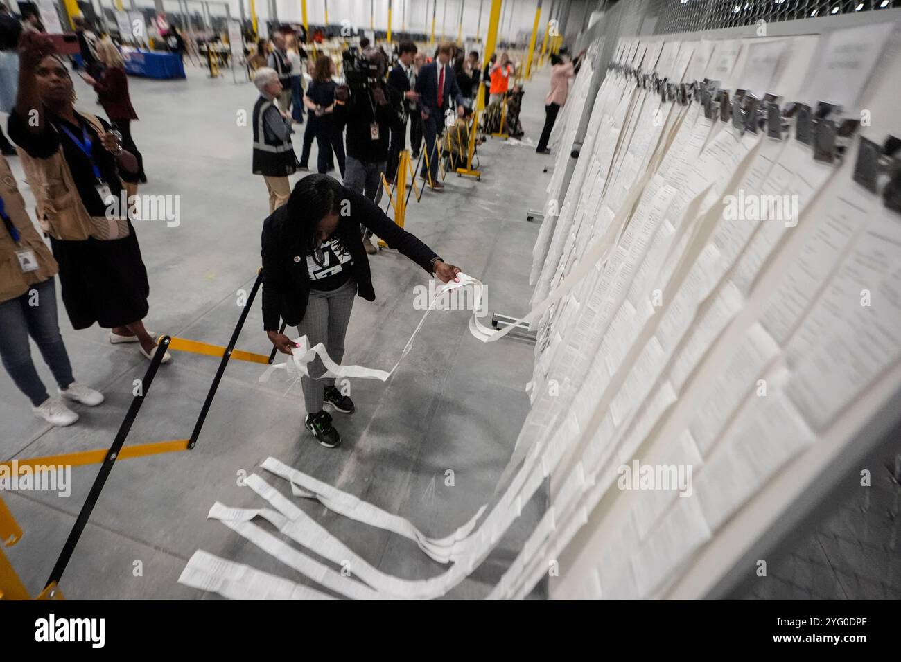 An elections staffer hangs scanner tapes used in early voting at the ...