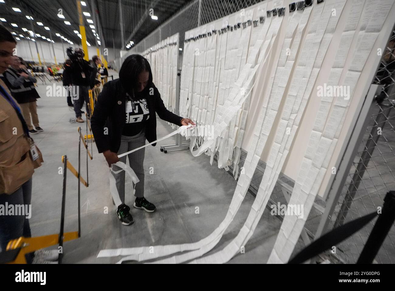 An elections staffer hangs scanner tapes used in early voting at the ...