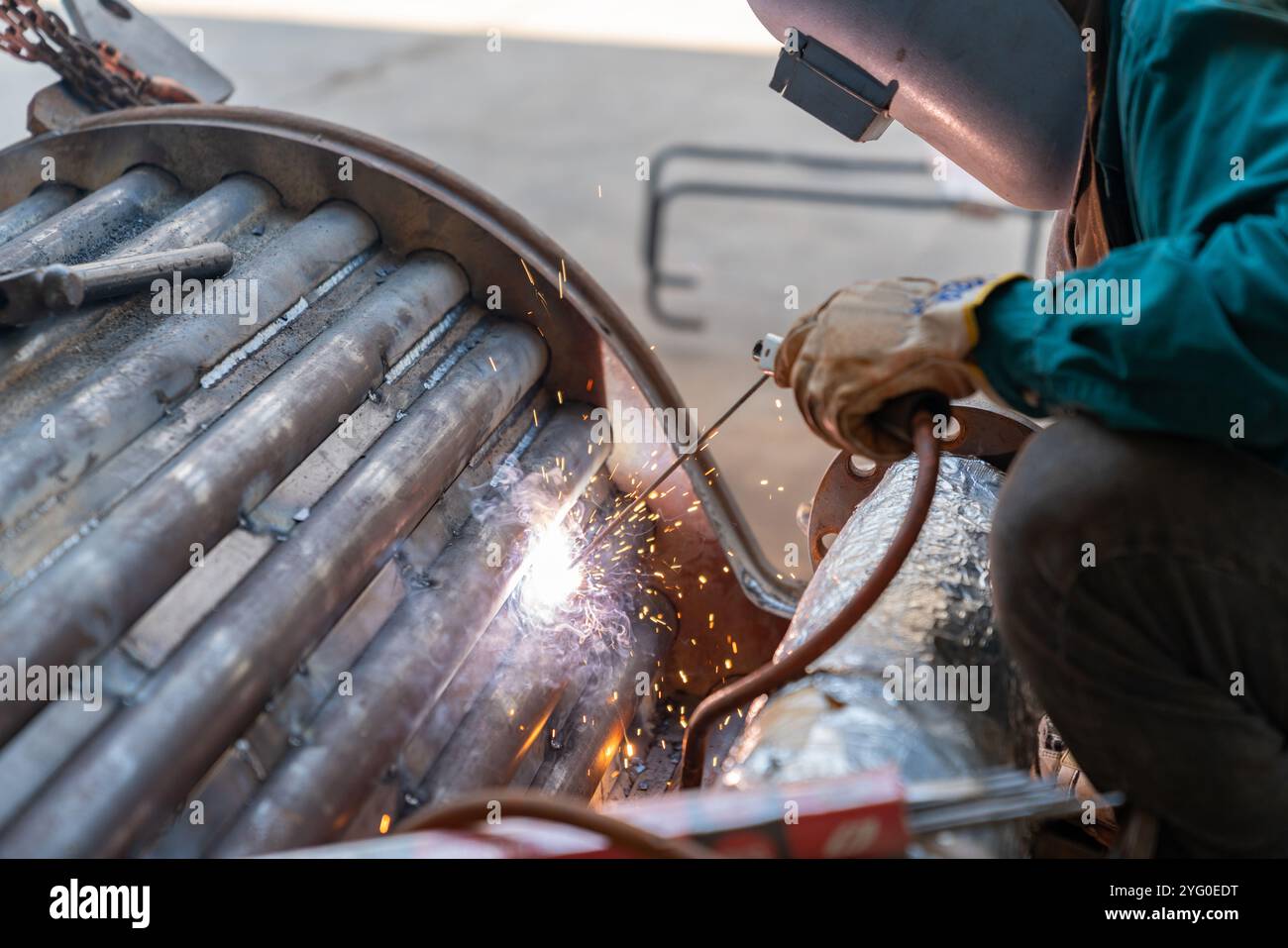 Welder is welding the metal tube of boiler in the factory Stock Photo ...