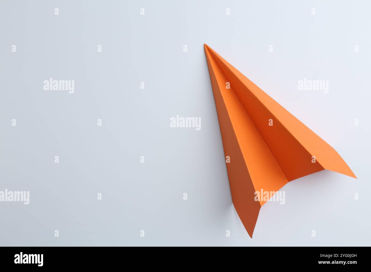 One handmade orange paper plane on white background, top view. Space ...