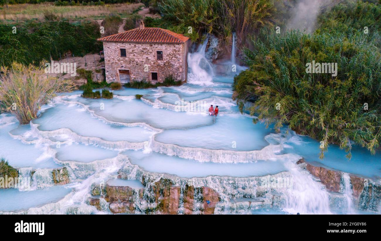 Visitors enjoy the soothing waters of Saturnia thermal baths, soaking ...