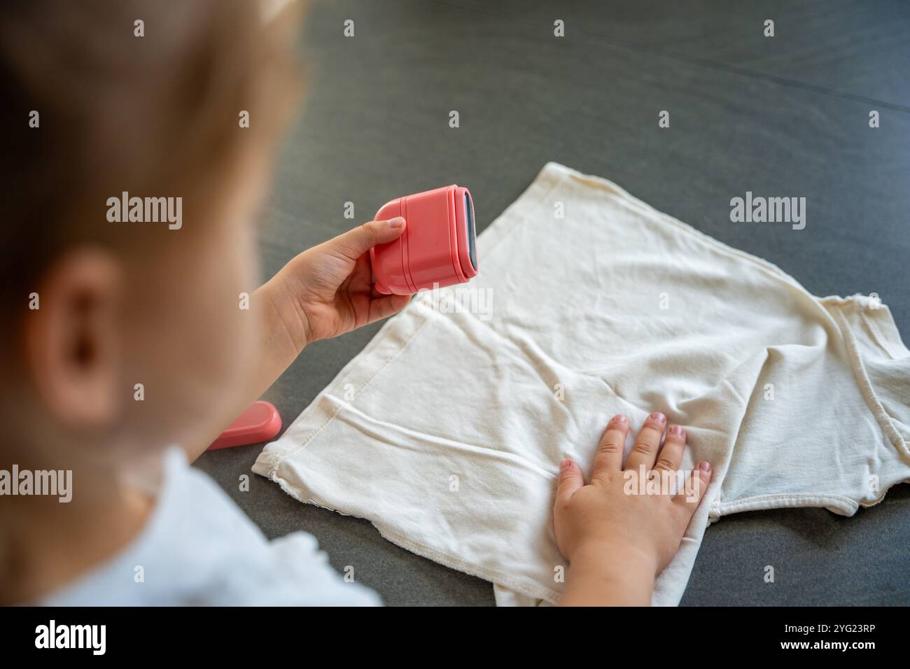 Back view of little girl with a stamp with a name for signing children ...