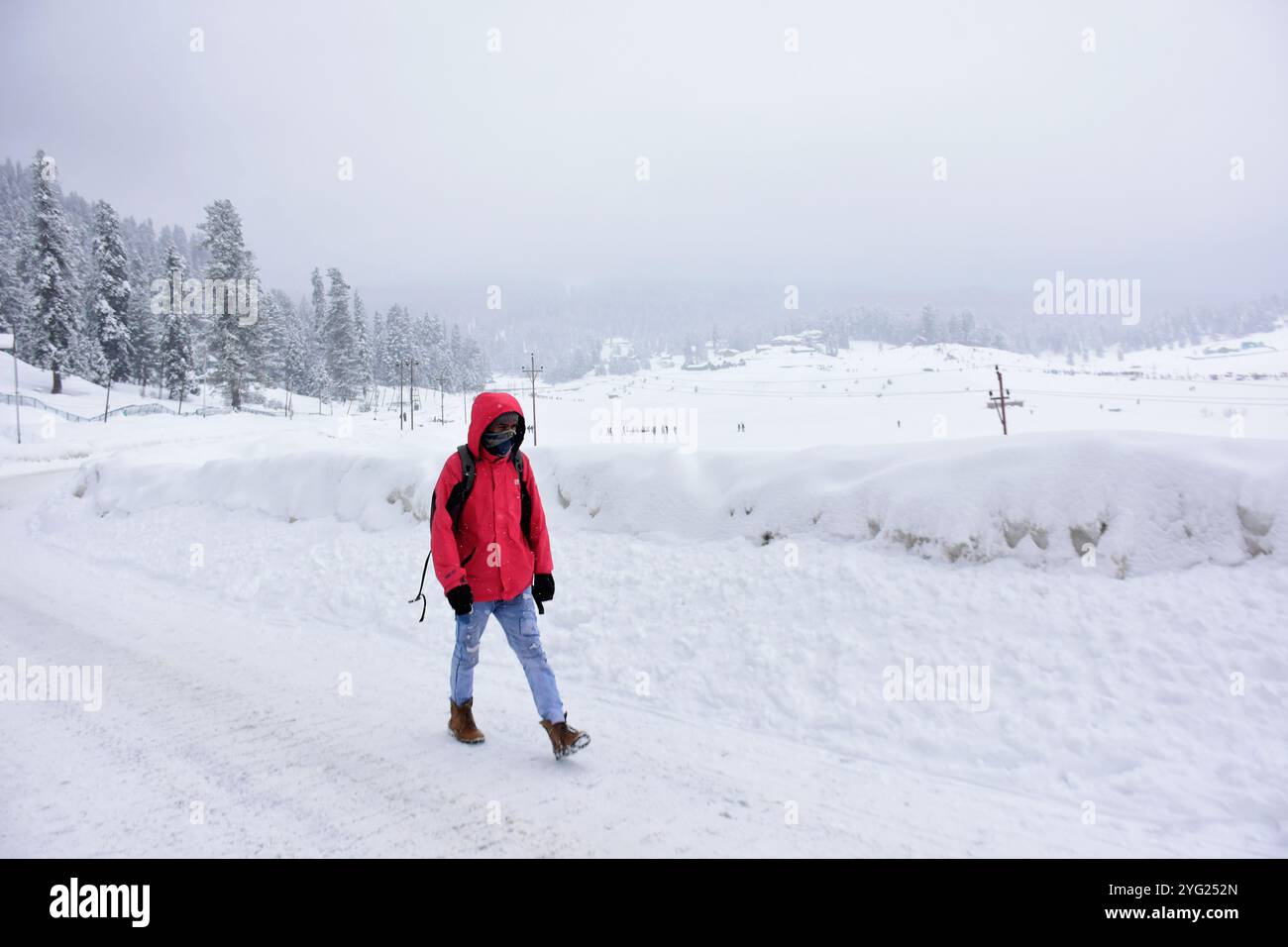 A man walks amid snowfall in Gulmard town of Baramulla district north ...