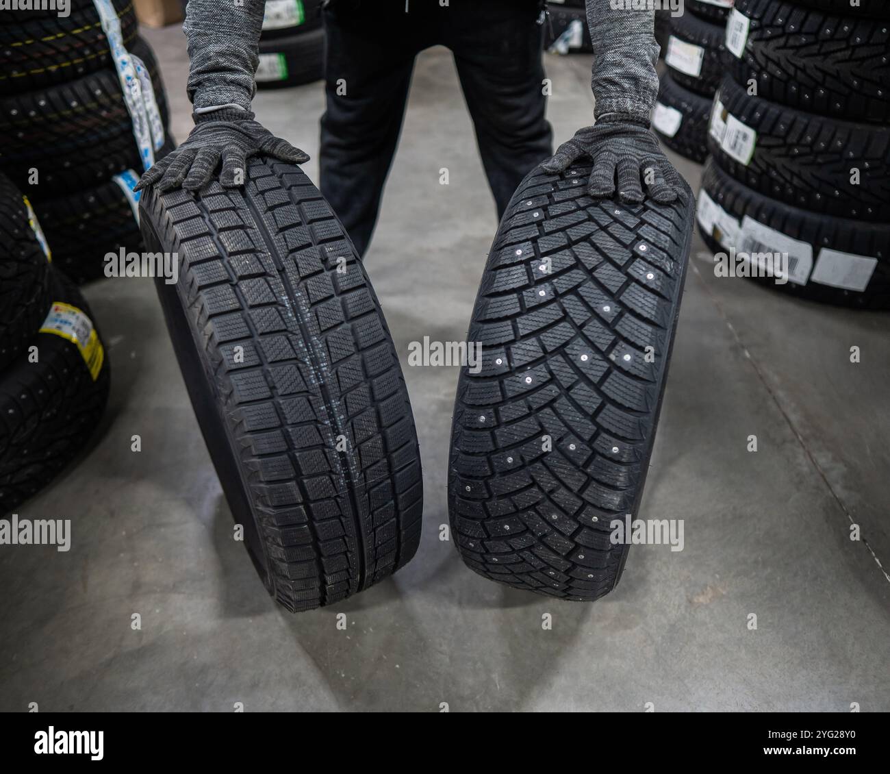 Mechanic keeps new summer and winter car tires in the garage. Comparison of wheels for different ...