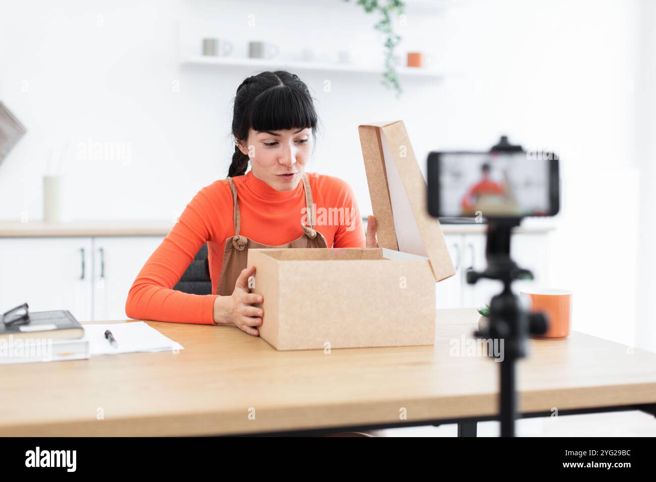 Caucasian female influencer unboxing products for online video ...