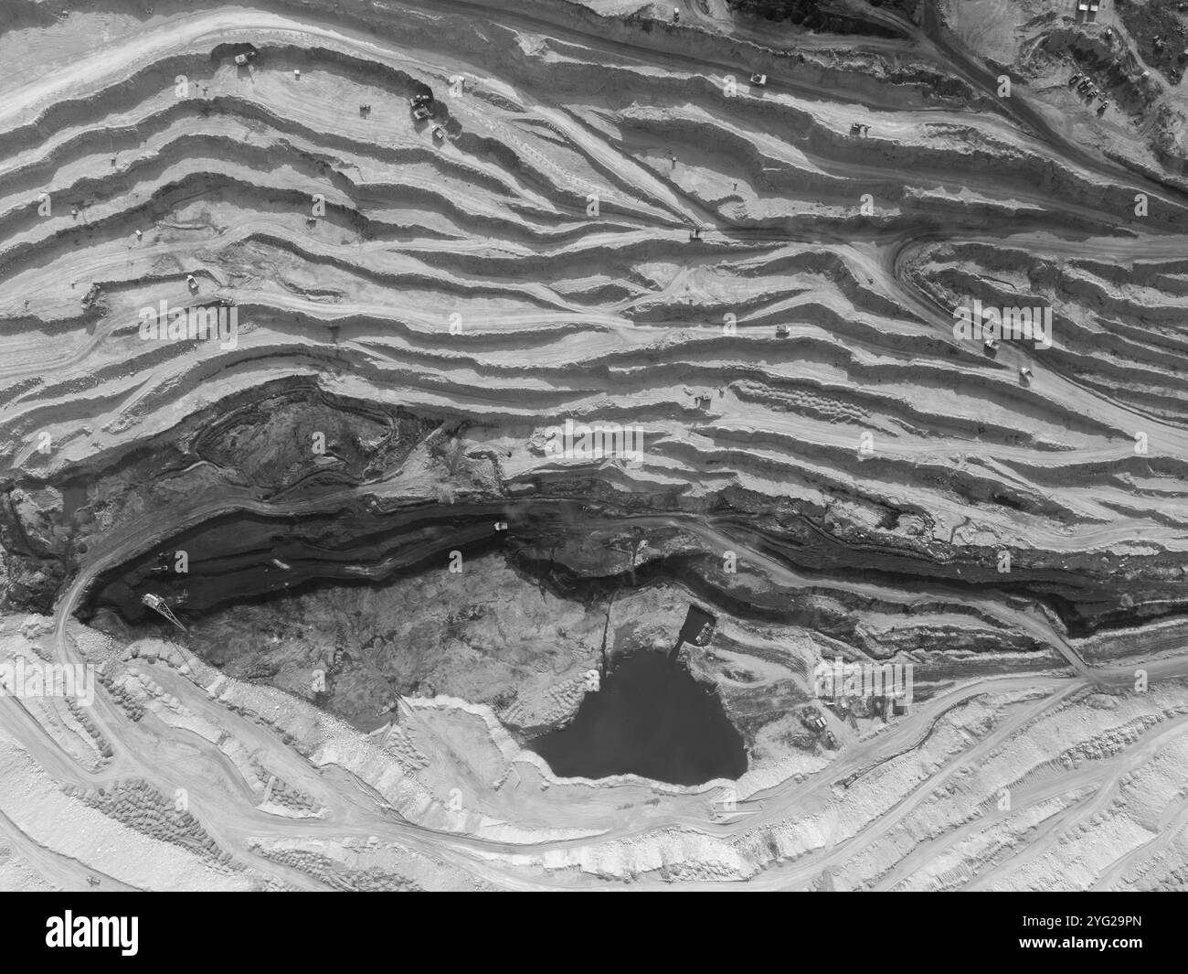 Monochrome panorama of a coal quarry with multi-level roads for trucks ...