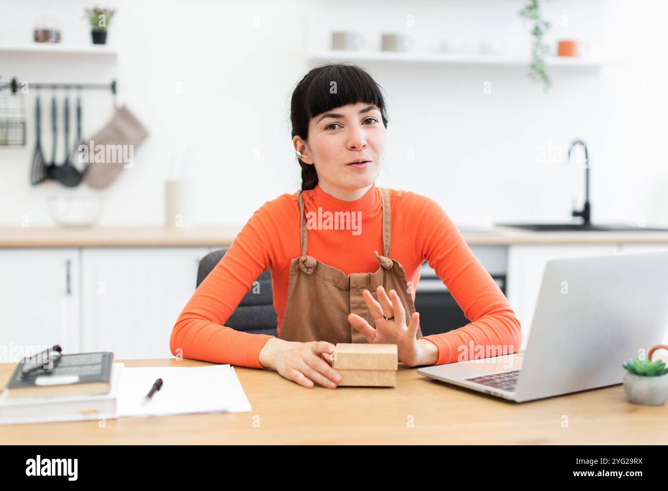 Young woman unboxing items during online live stream Stock Photo - Alamy