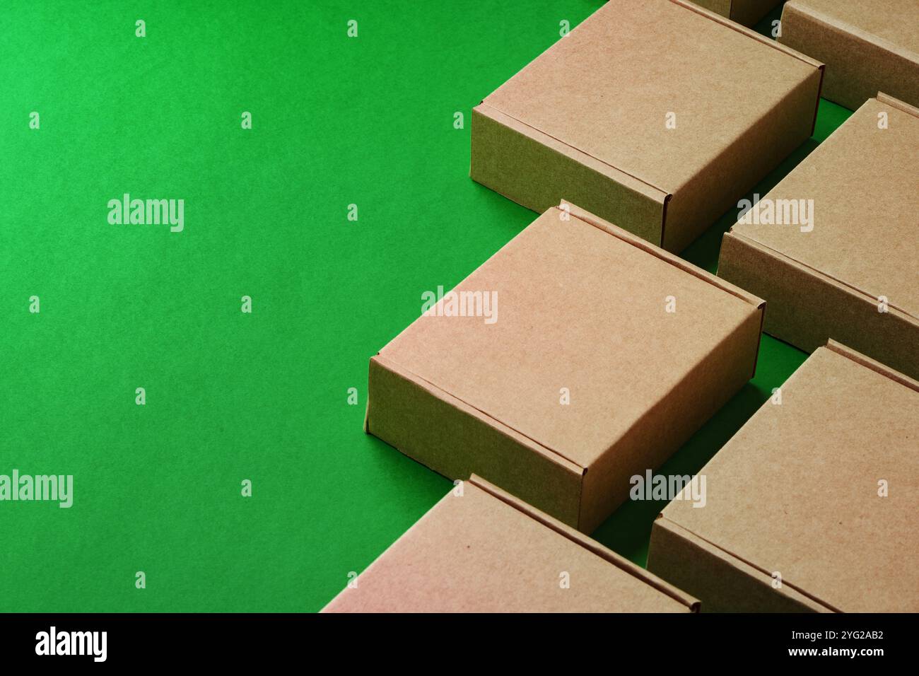 Brown cardboard boxes arranged on a vibrant green surface Stock Photo ...