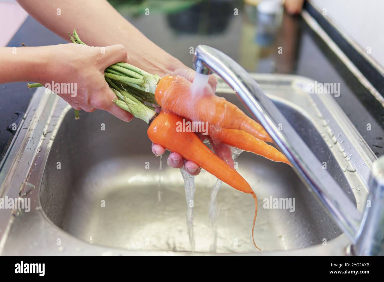 Woman cleaning carrots kitchen hi-res stock photography and images - Alamy