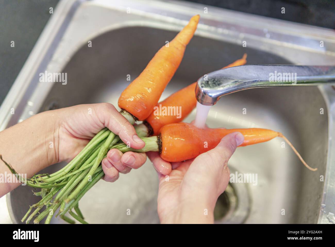 Woman cleaning carrots kitchen hi-res stock photography and images - Alamy