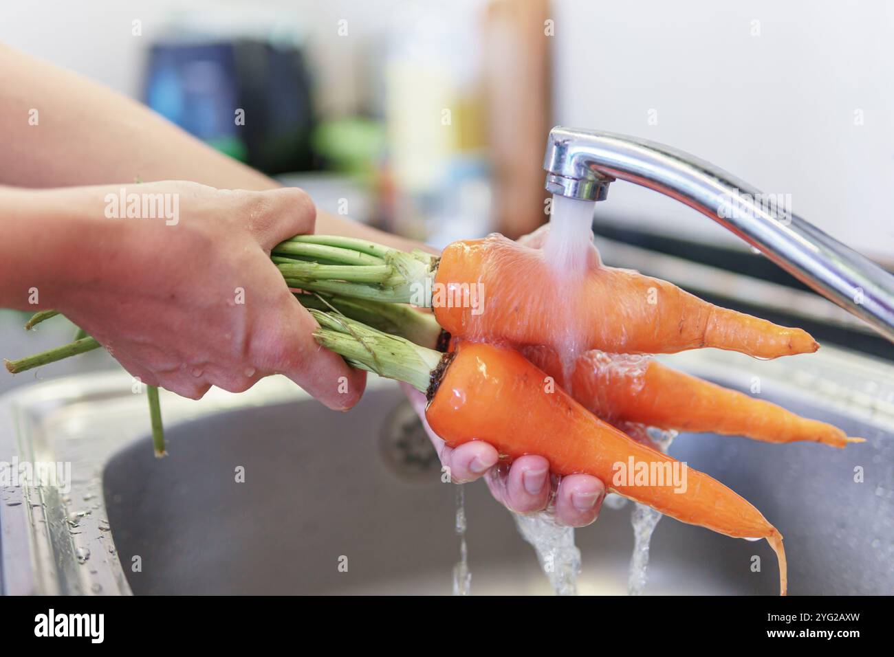 Woman cleaning carrots kitchen hi-res stock photography and images - Alamy